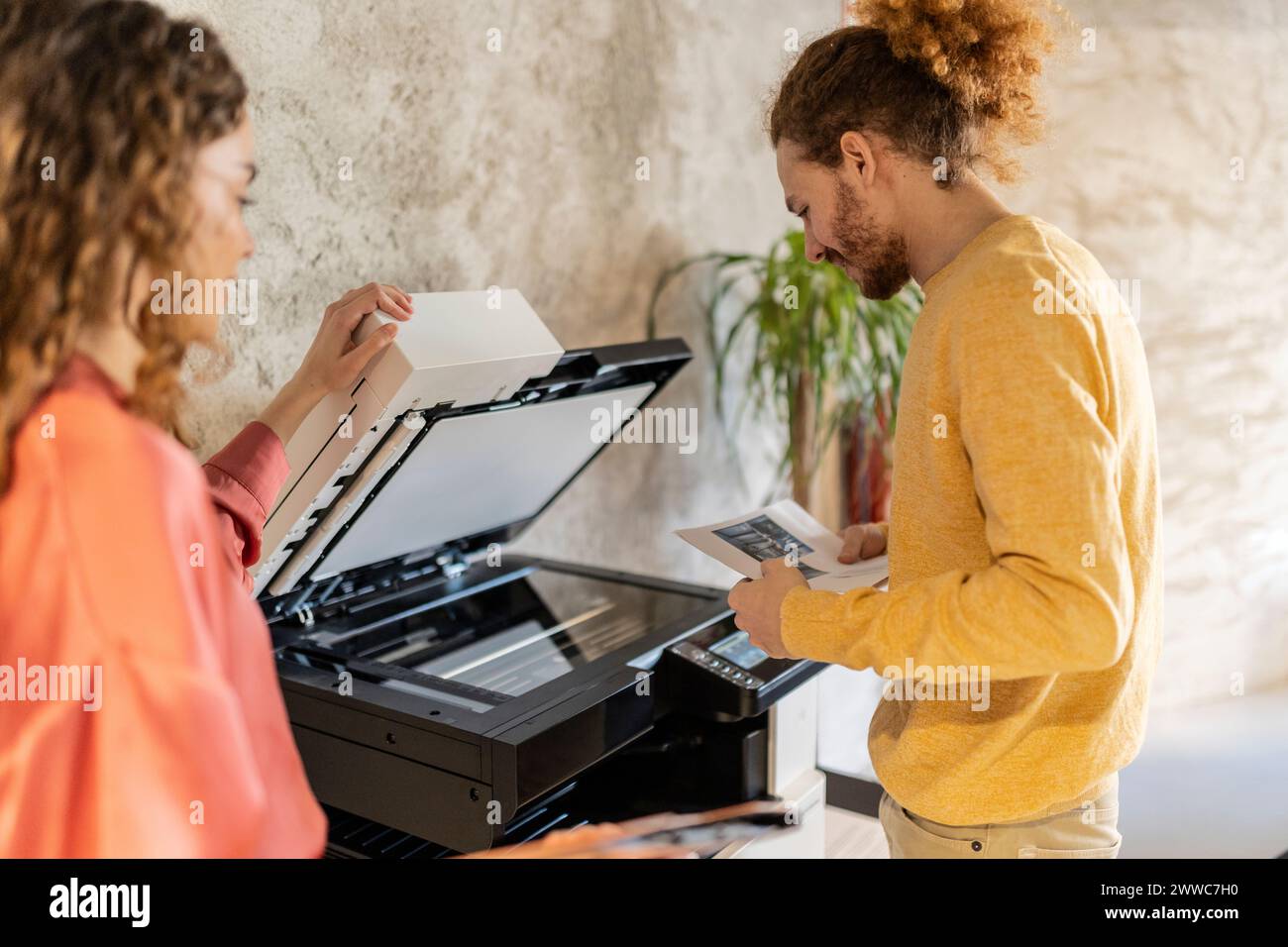 Businessman using photocopier machine with colleague at office Stock ...