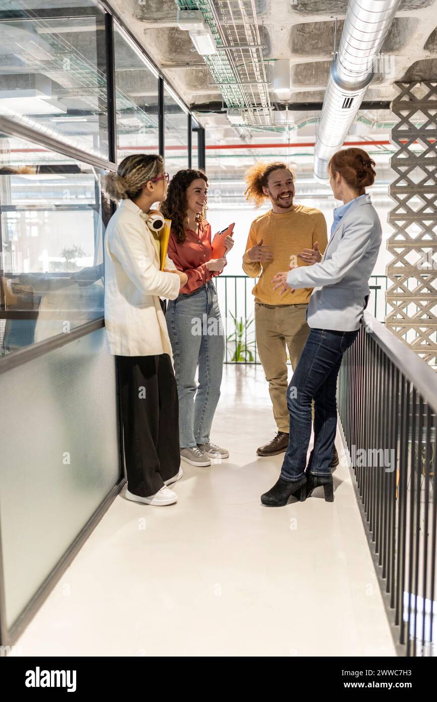Business colleagues talking at office corridor Stock Photo - Alamy