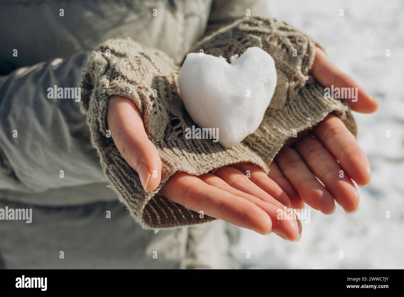 Woman holding heart shaped snowball in hand Stock Photo - Alamy