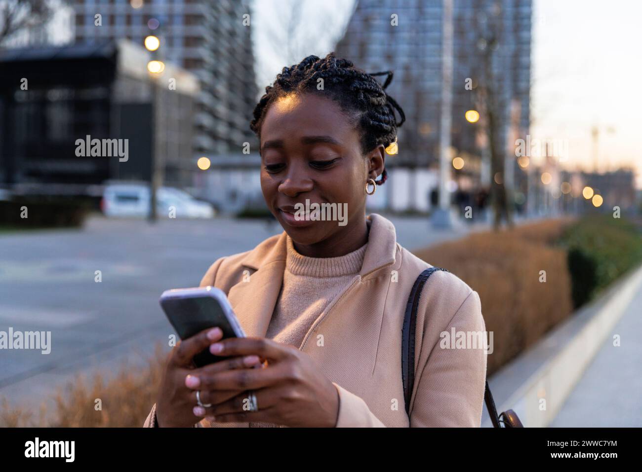 Woman smiles using smartphone hi-res stock photography and images - Alamy