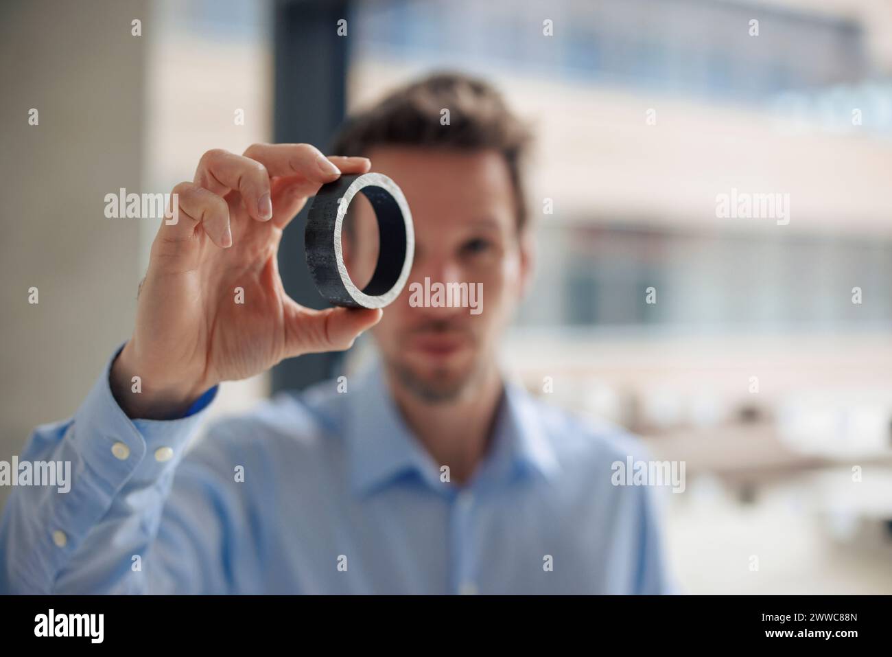 Engineer holding round metal object at workshop Stock Photo - Alamy