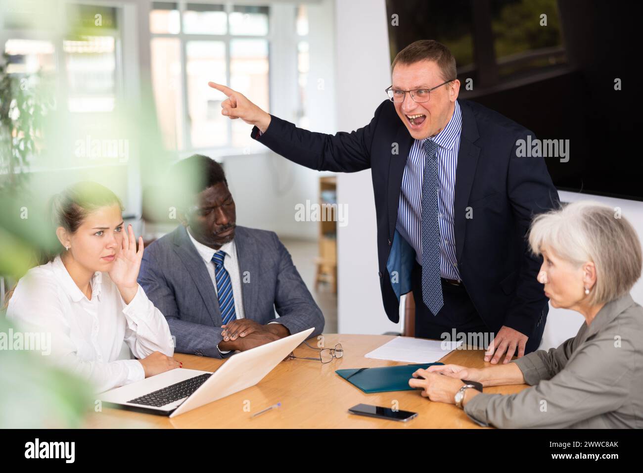 Group of different people arguing at table in office Stock Photo - Alamy