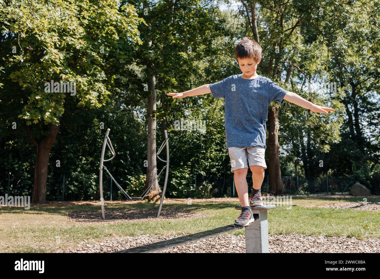 Boy balancing on metal structure in playground Stock Photo - Alamy