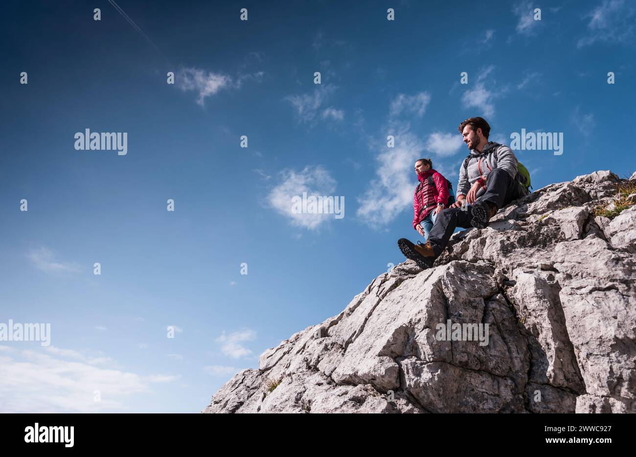 Man sitting near girlfriend on mountain peak at Bavarian Alps Stock ...