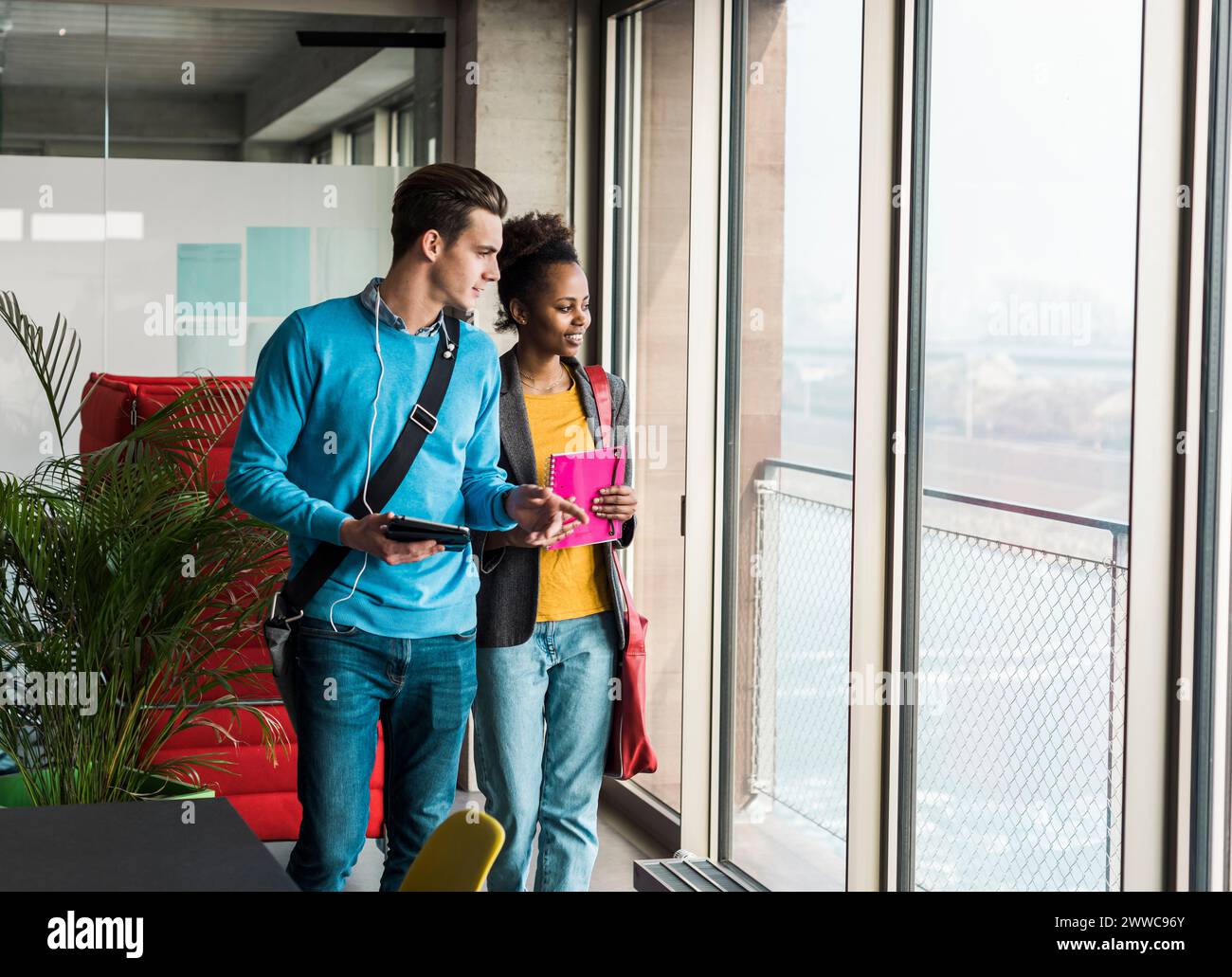 Business colleagues looking out of window at office Stock Photo - Alamy