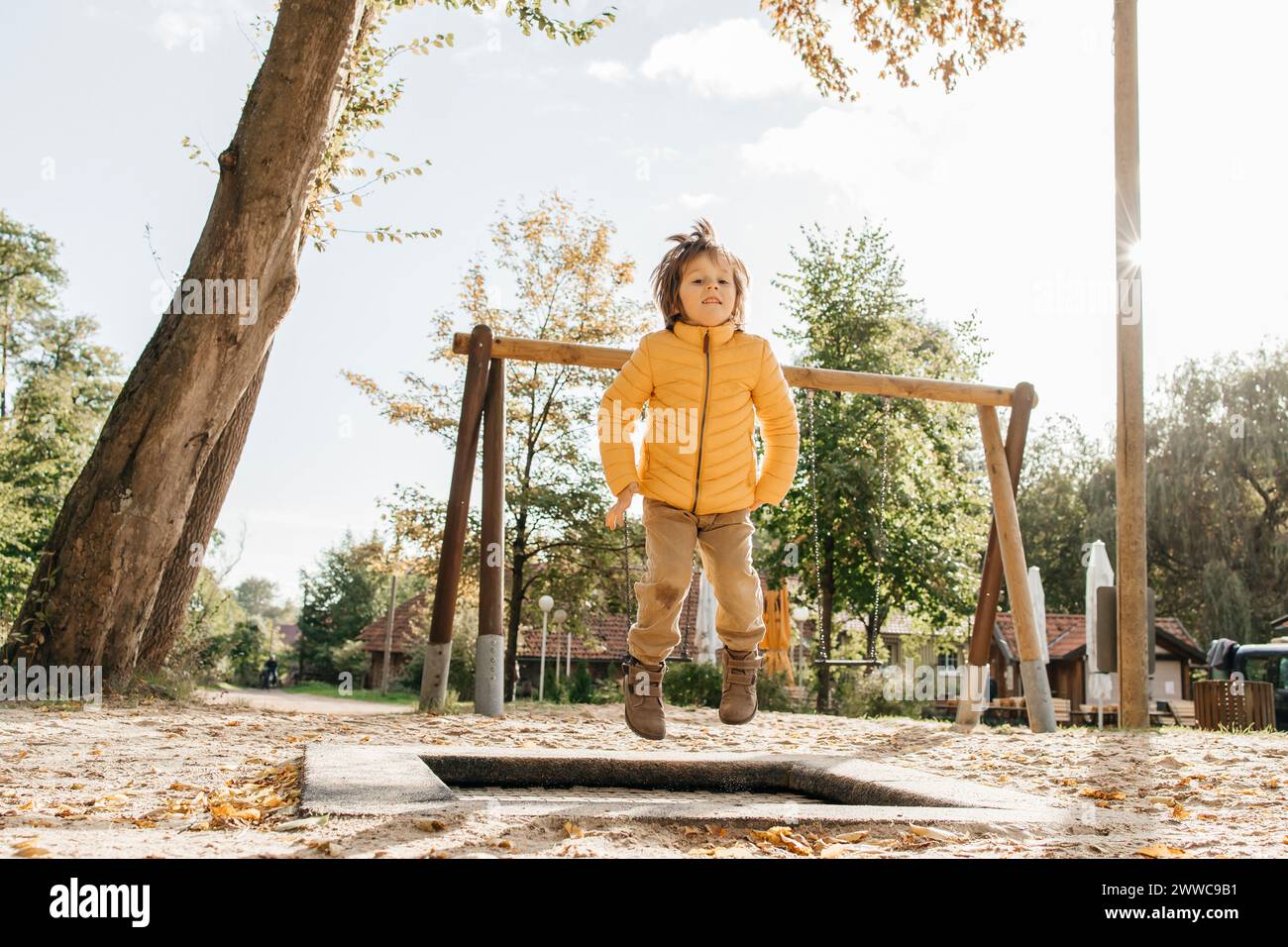 Little boy jumping on trampoline at playground Stock Photo - Alamy
