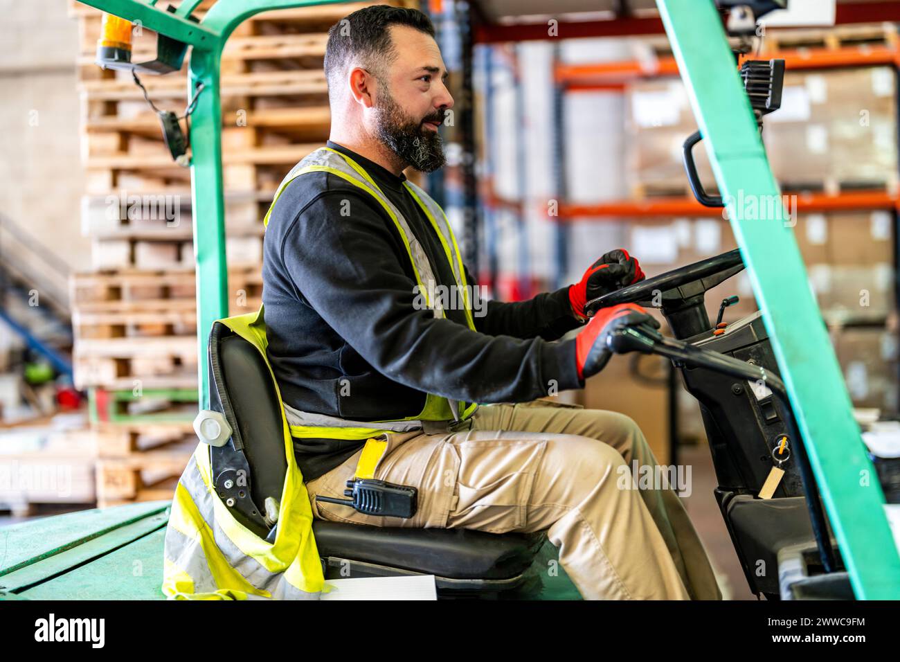 Mature worker driving forklift at warehouse Stock Photo - Alamy