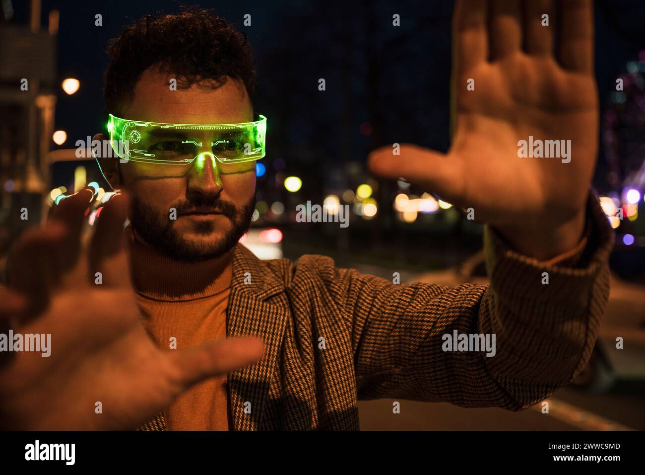 Man wearing smart glasses and gesturing at night Stock Photo - Alamy