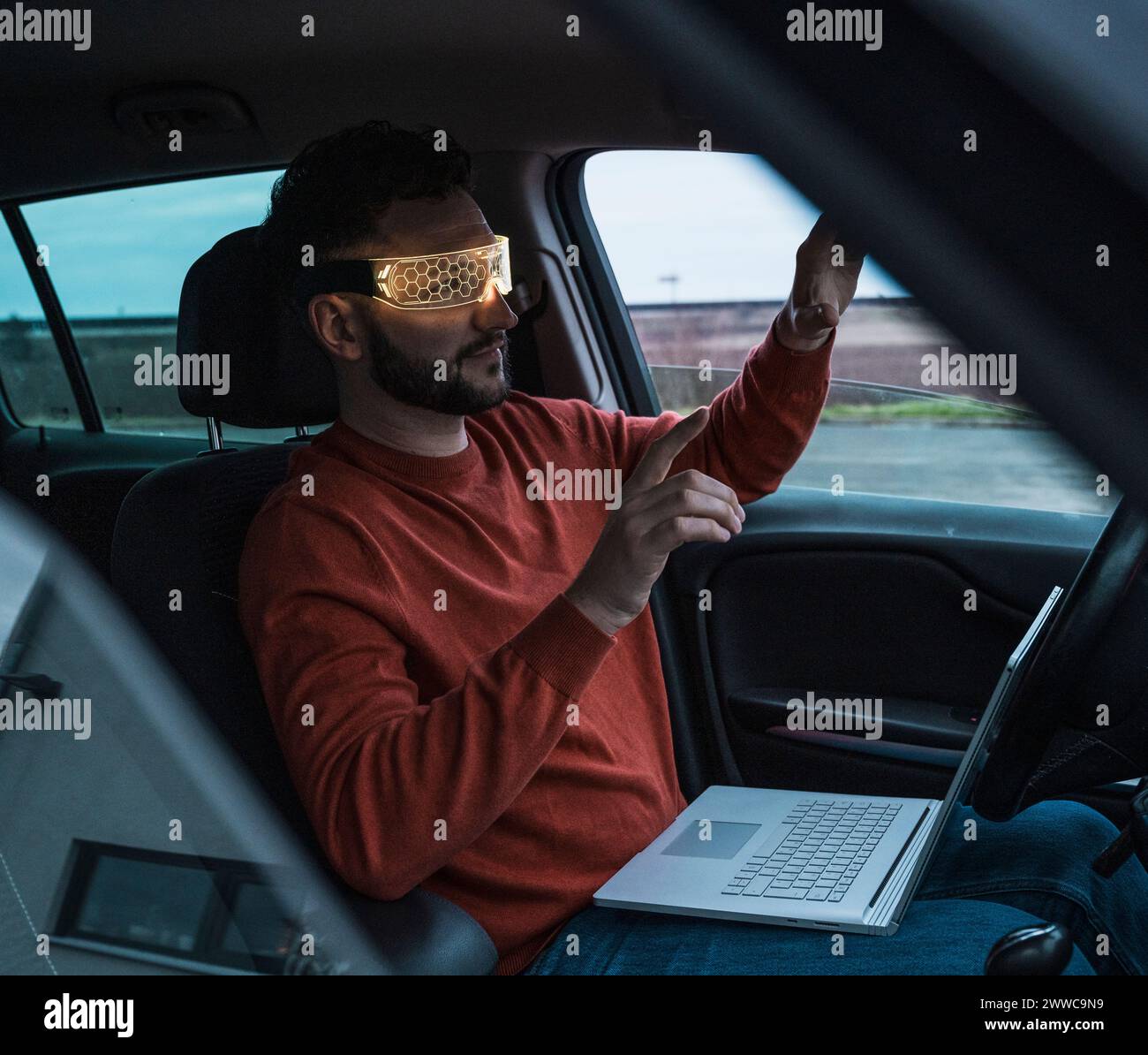 Freelancer sitting with laptop and wearing smart glasses in car Stock ...