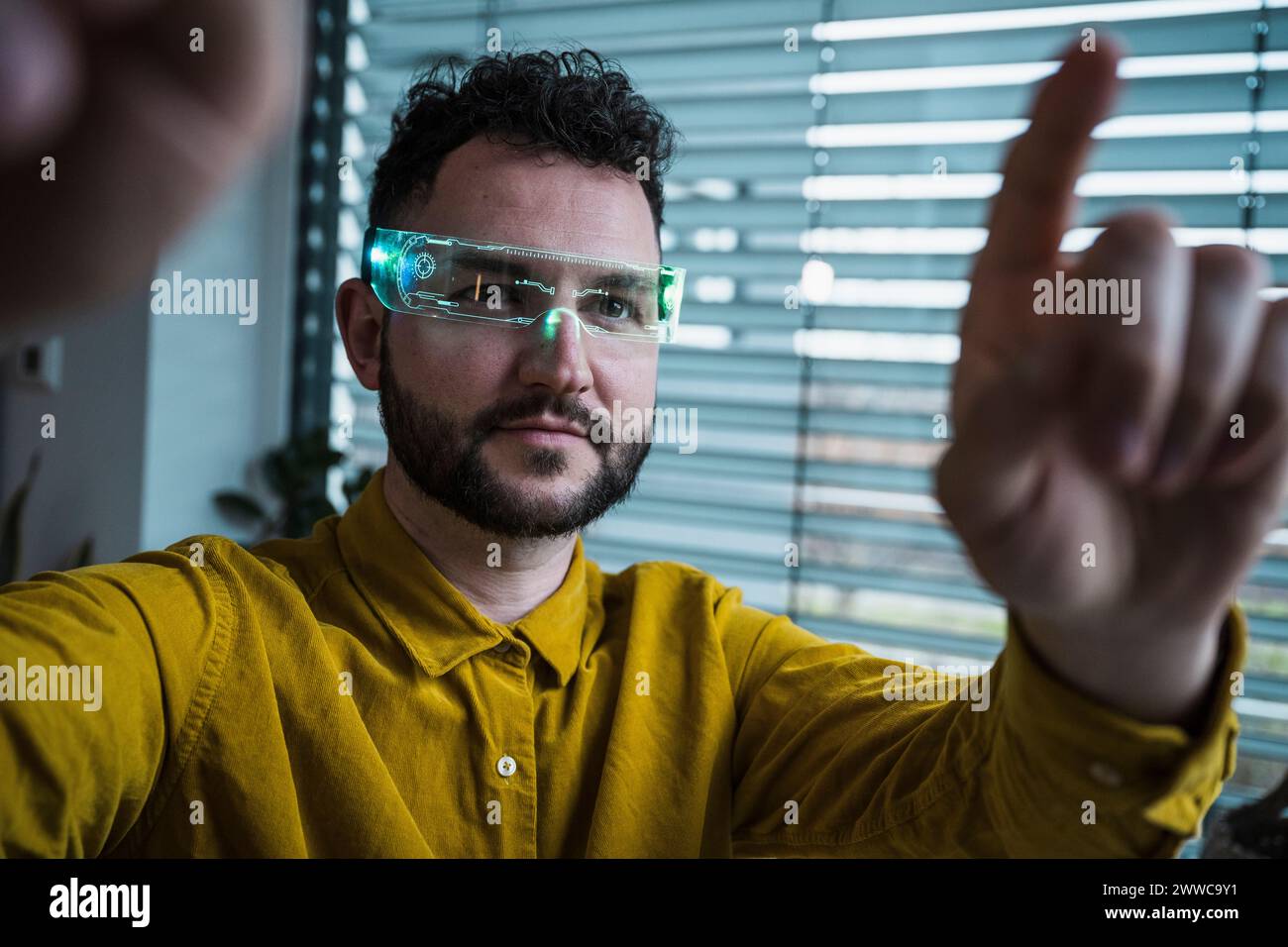 Man wearing smart glasses and gesturing near window Stock Photo - Alamy
