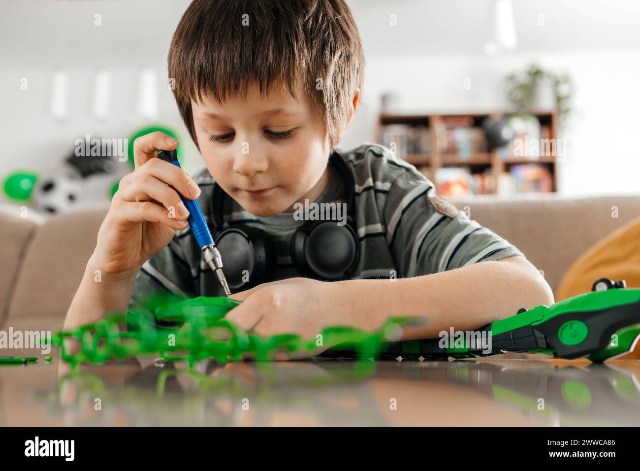 Boy making toy model using screwdriver at home Stock Photo - Alamy