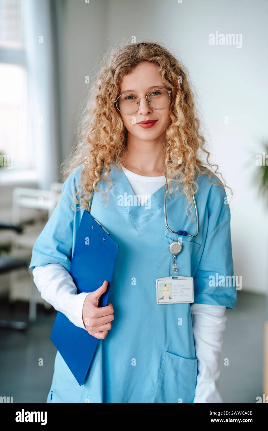 Doctor with curly hair wearing scrubs in hospital Stock Photo - Alamy