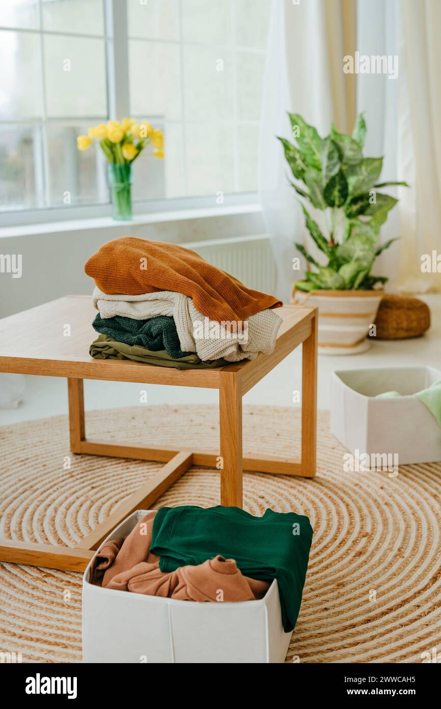 Clothes on table and in boxes over carpet at home Stock Photo - Alamy