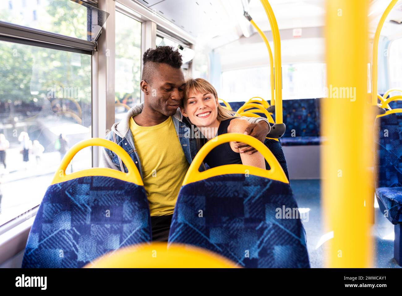 Man sitting with arm around friend in double-decker bus Stock Photo - Alamy