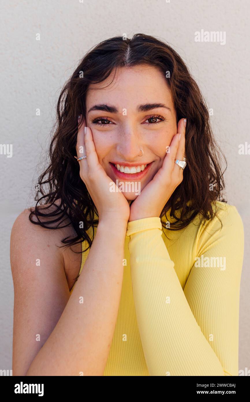 Happy woman with hands on cheek against white background Stock Photo ...