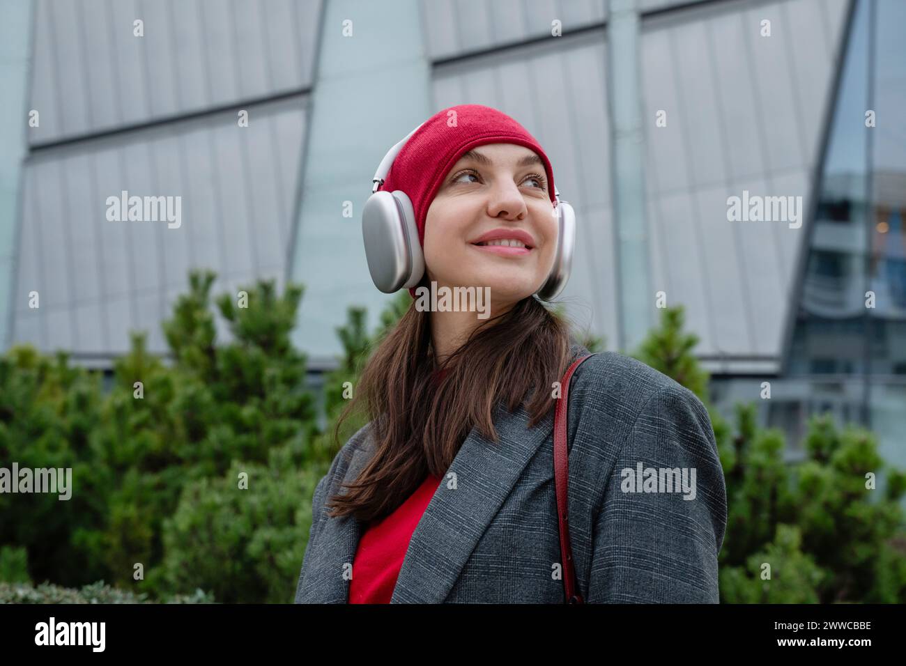 Happy young woman wearing wireless headphones listening to music Stock Photo - Alamy