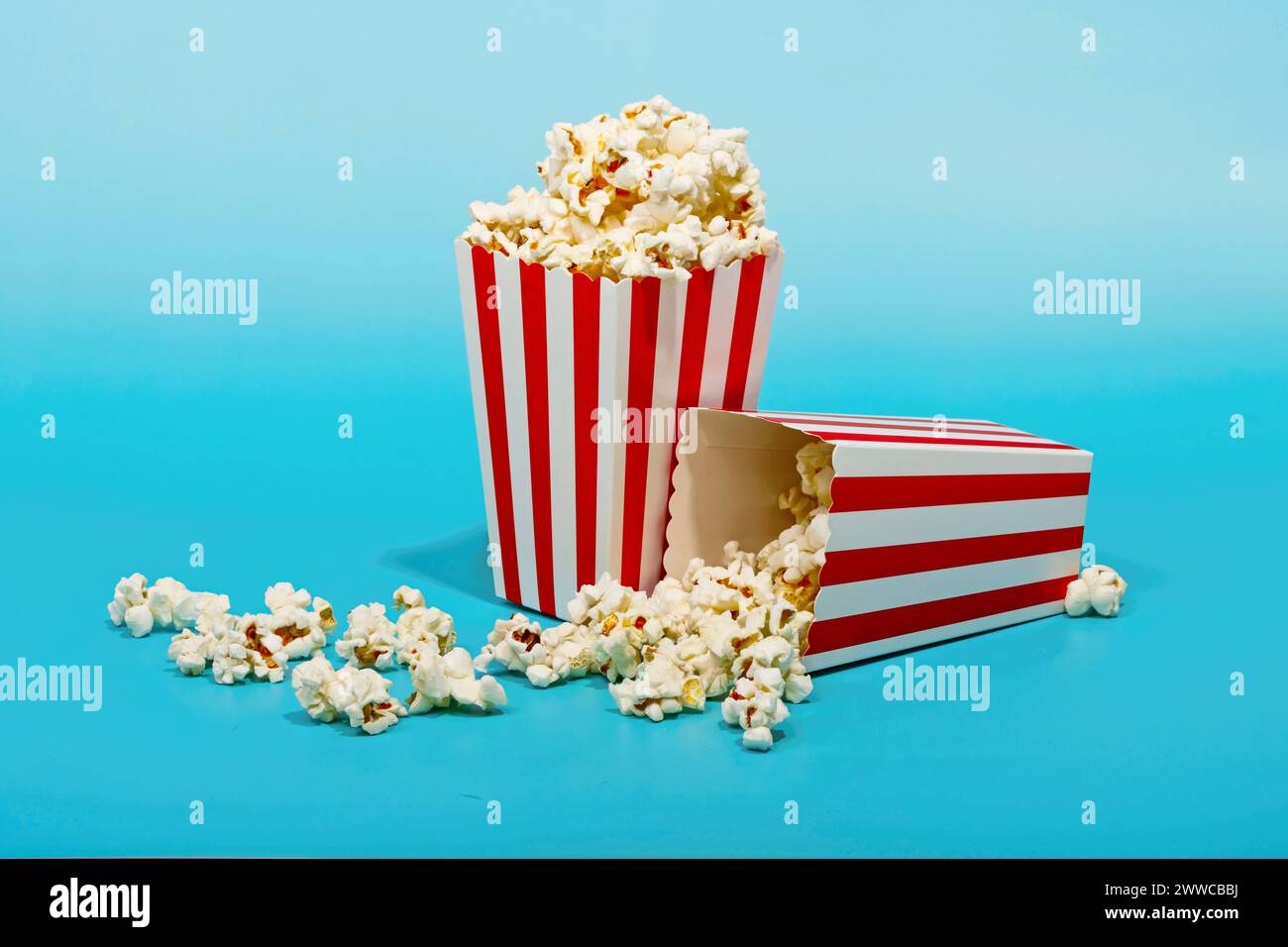 Red striped bucket with popcorn over blue background Stock Photo - Alamy
