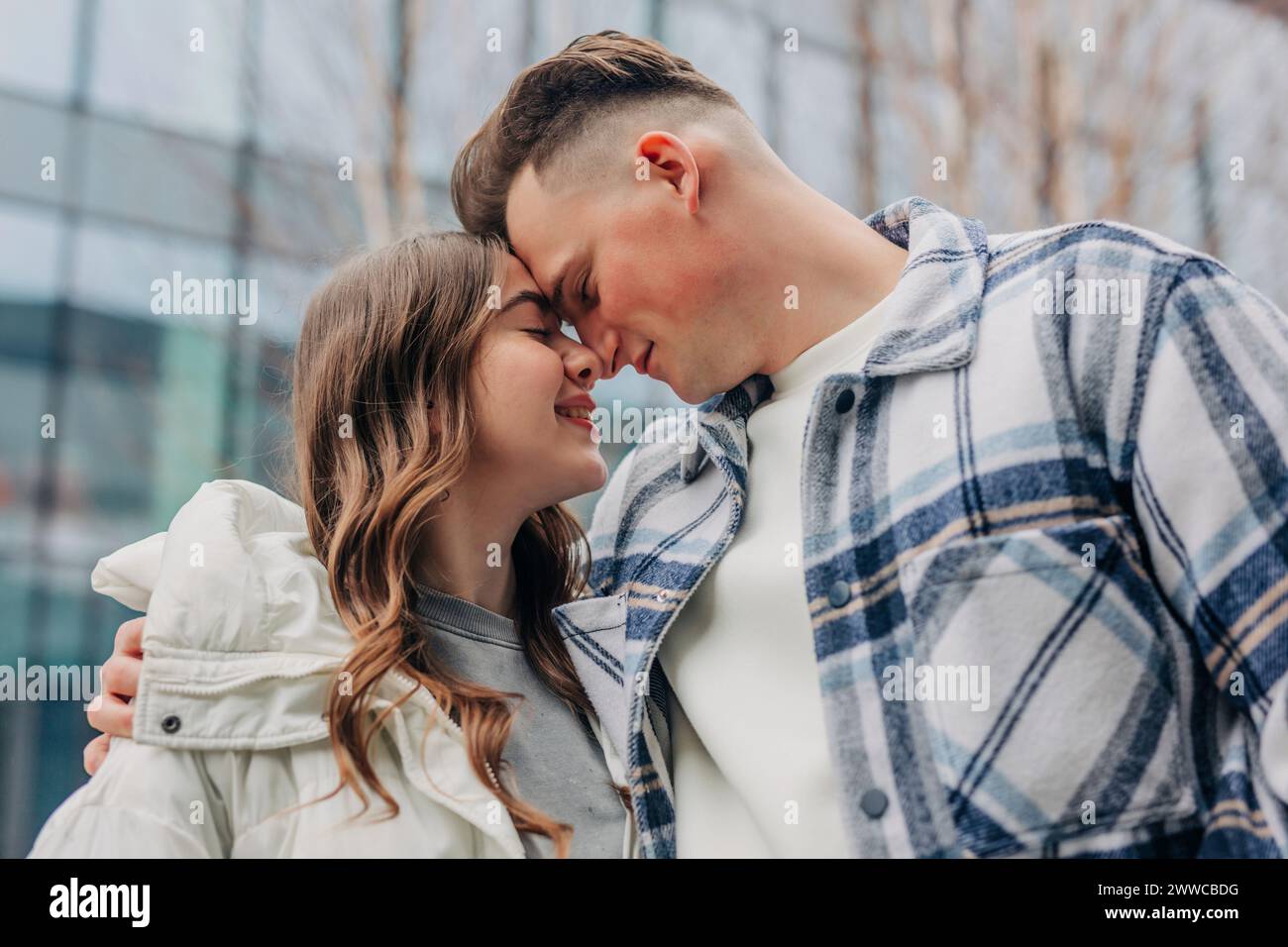 Romantic young couple rubbing noses in front of building Stock Photo - Alamy