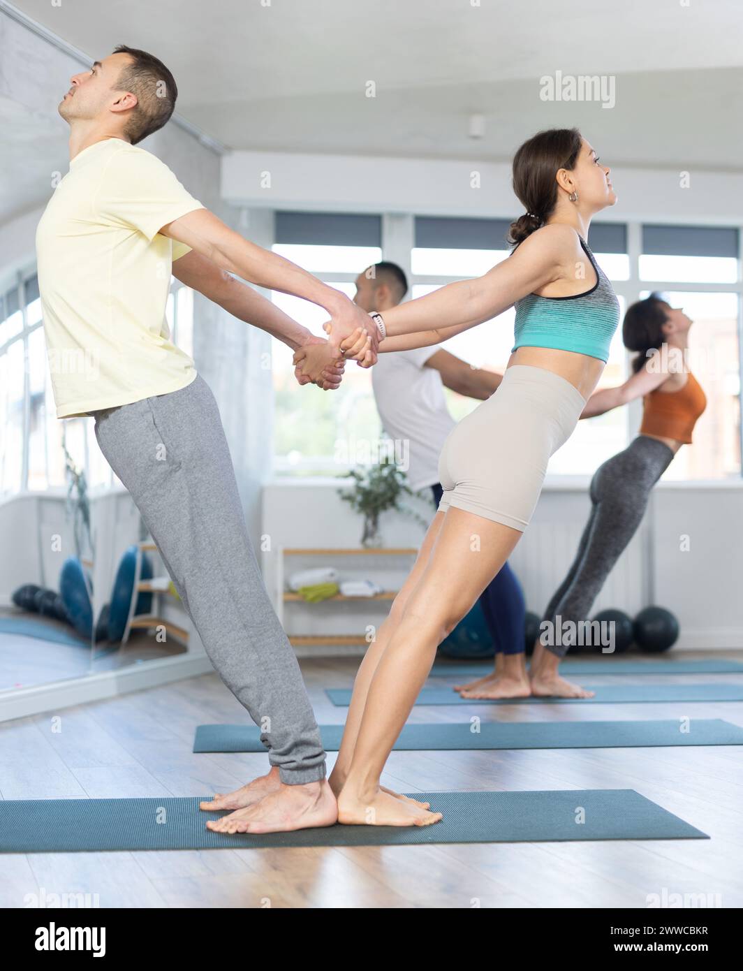 Lovers of active lifestyle perform pair yoga backbend balance pose in ...