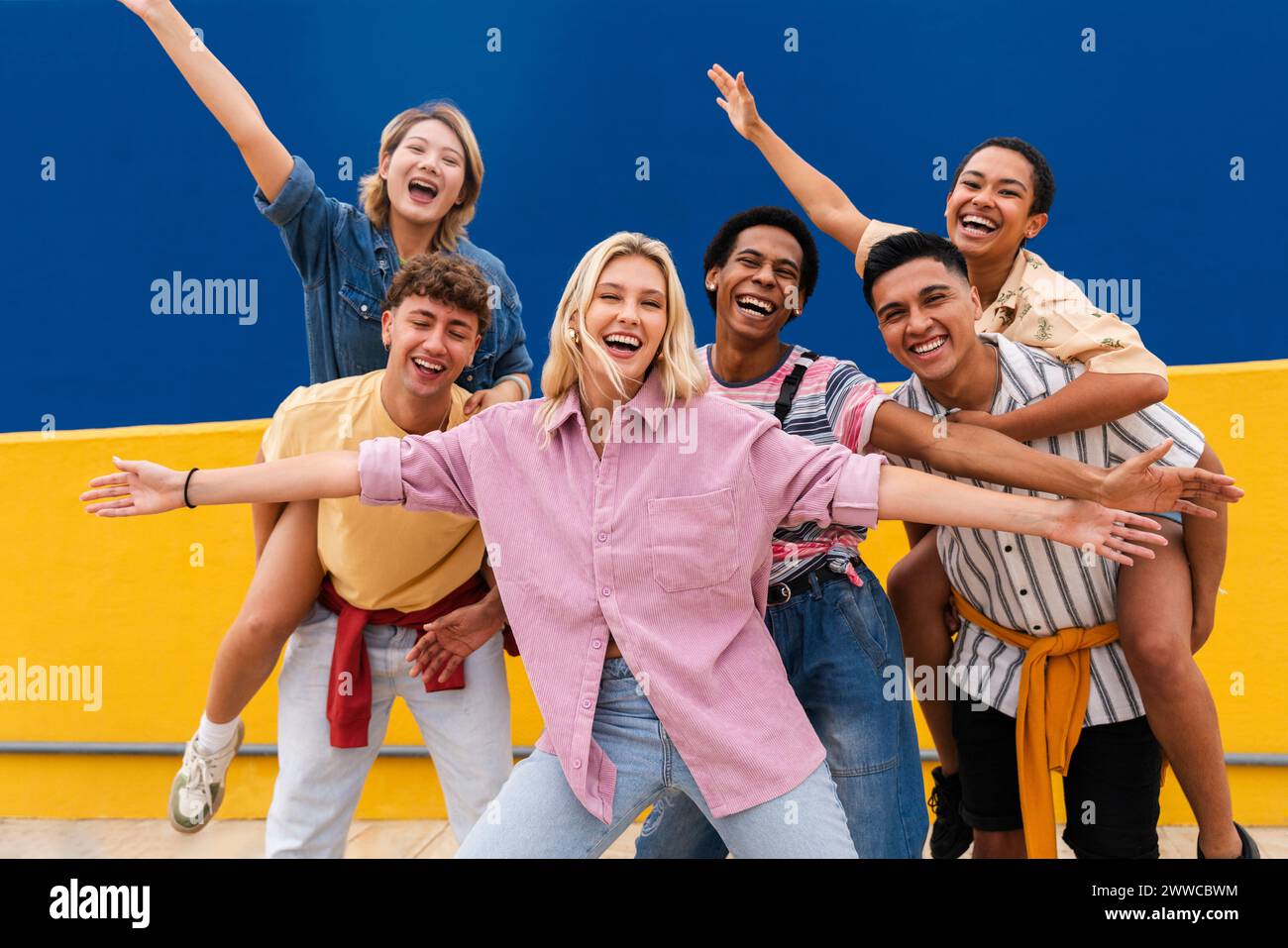 Group of young friends with colorful clothing posing happily in front ...