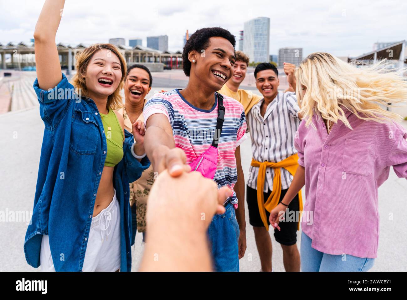 Happy young friends holding hands and having fun together Stock Photo ...