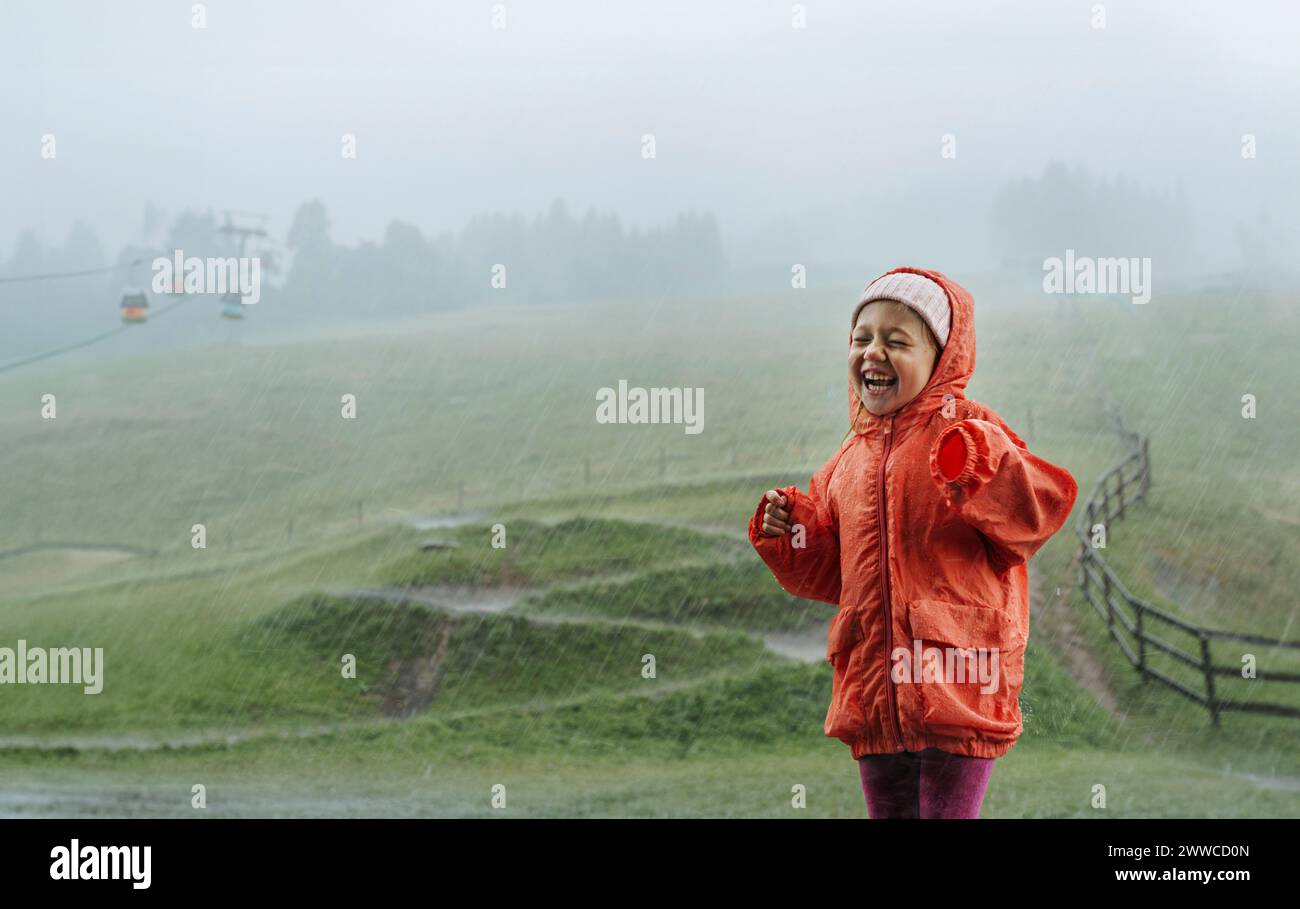 Happy girl standing in rain Stock Photo - Alamy
