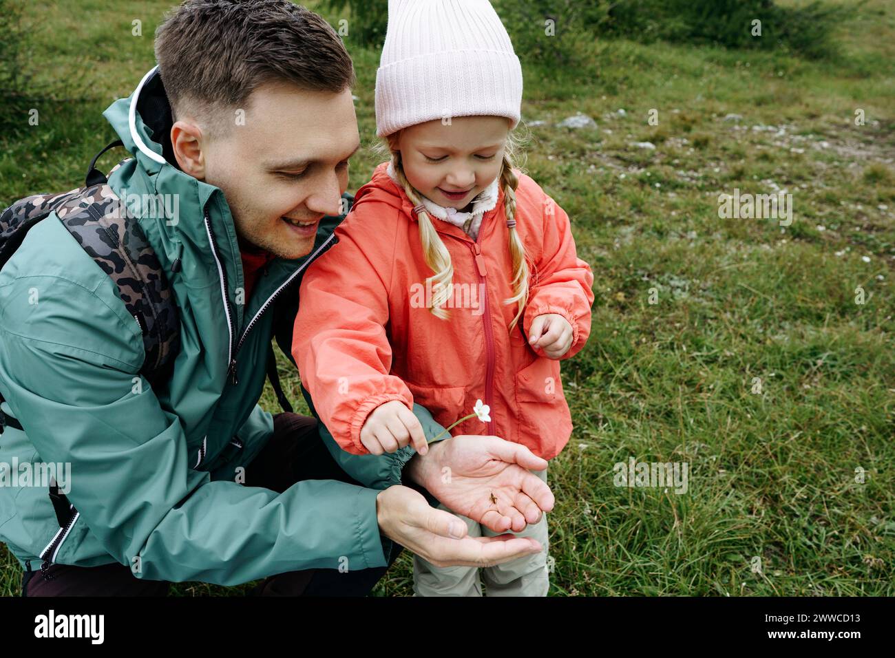 Smiling father showing bug and flower to daughter Stock Photo - Alamy