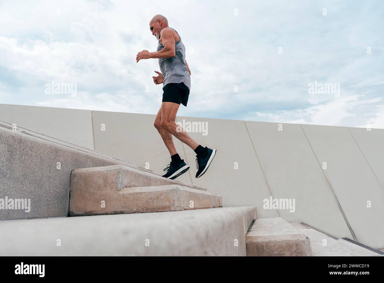 Active senior man moving up on steps Stock Photo - Alamy