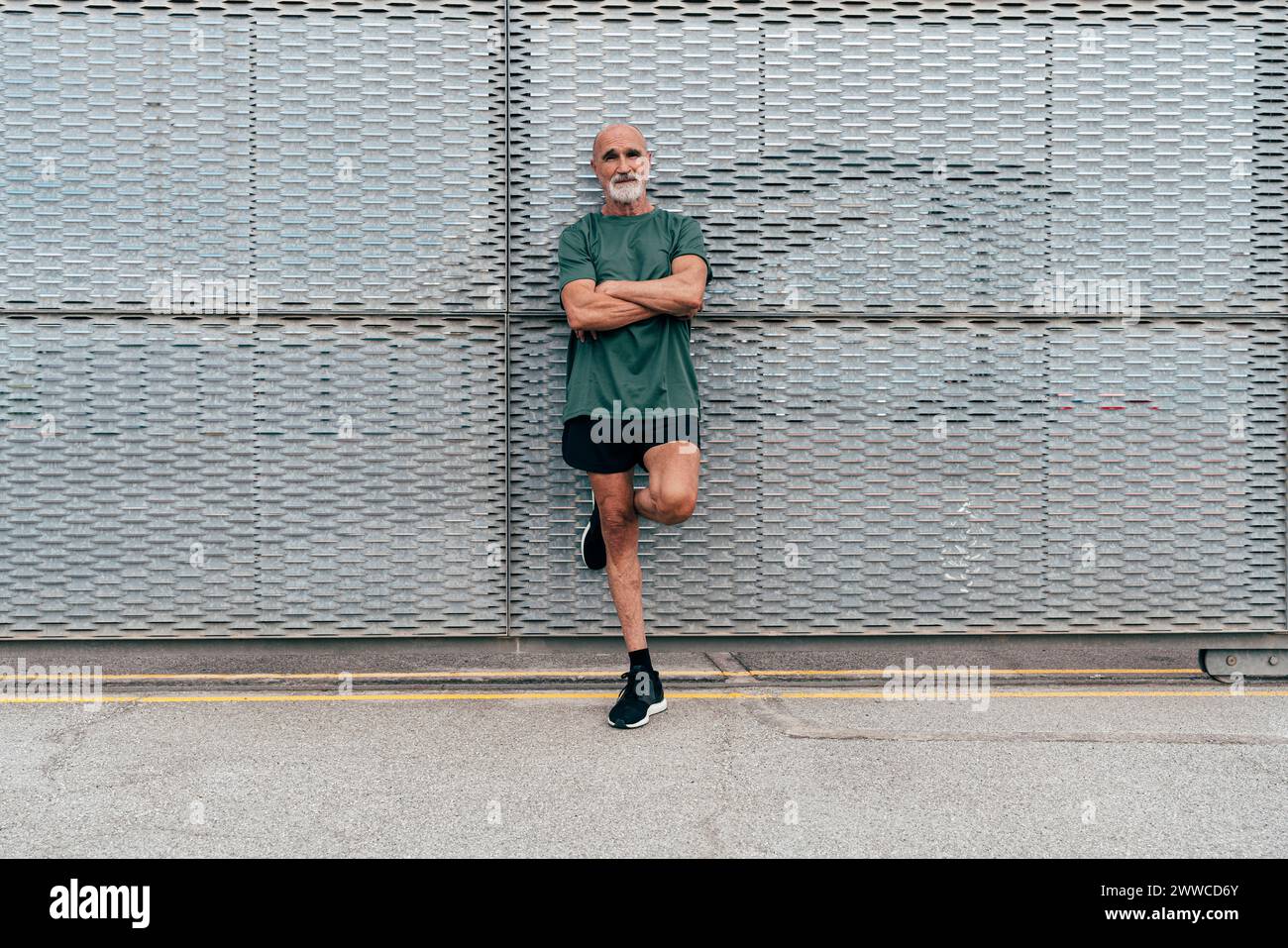 Retired man with arms crossed leaning on fence Stock Photo - Alamy
