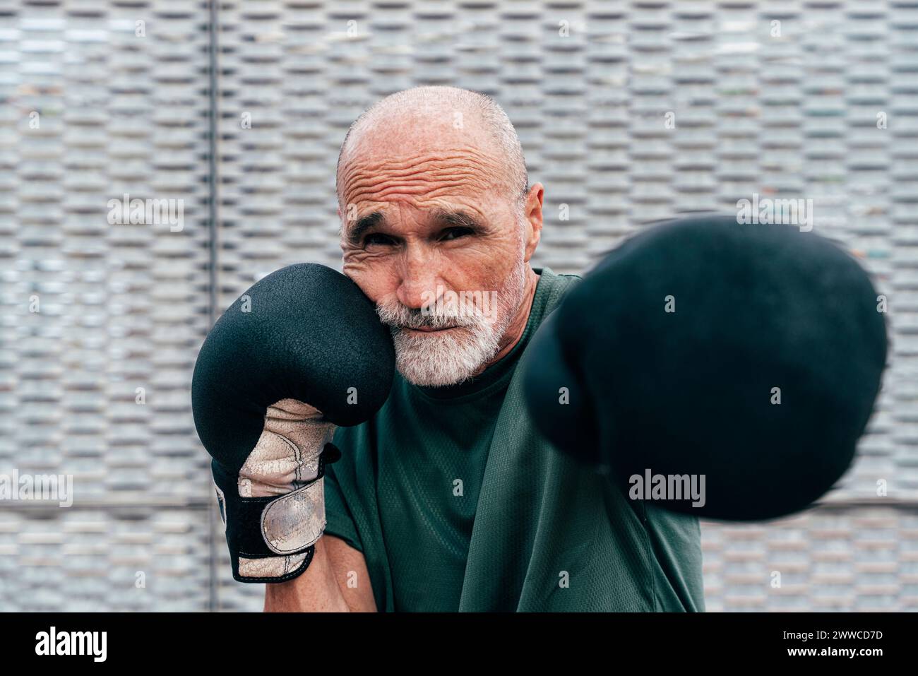 Confident active senior man practicing with boxing gloves Stock Photo ...