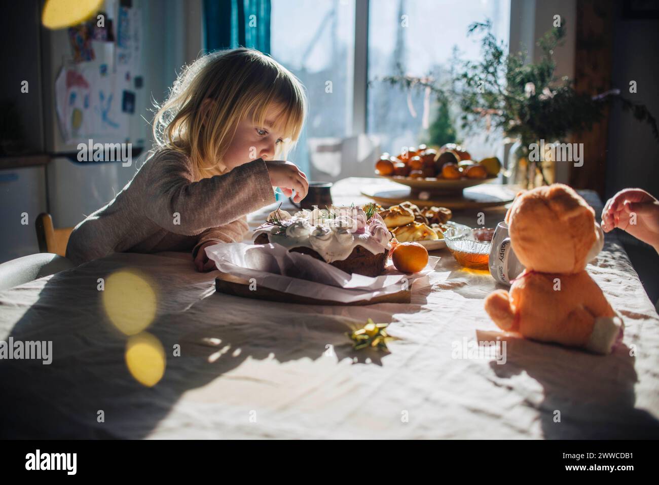 Girl decorating birthday cake on dining table at home Stock Photo - Alamy