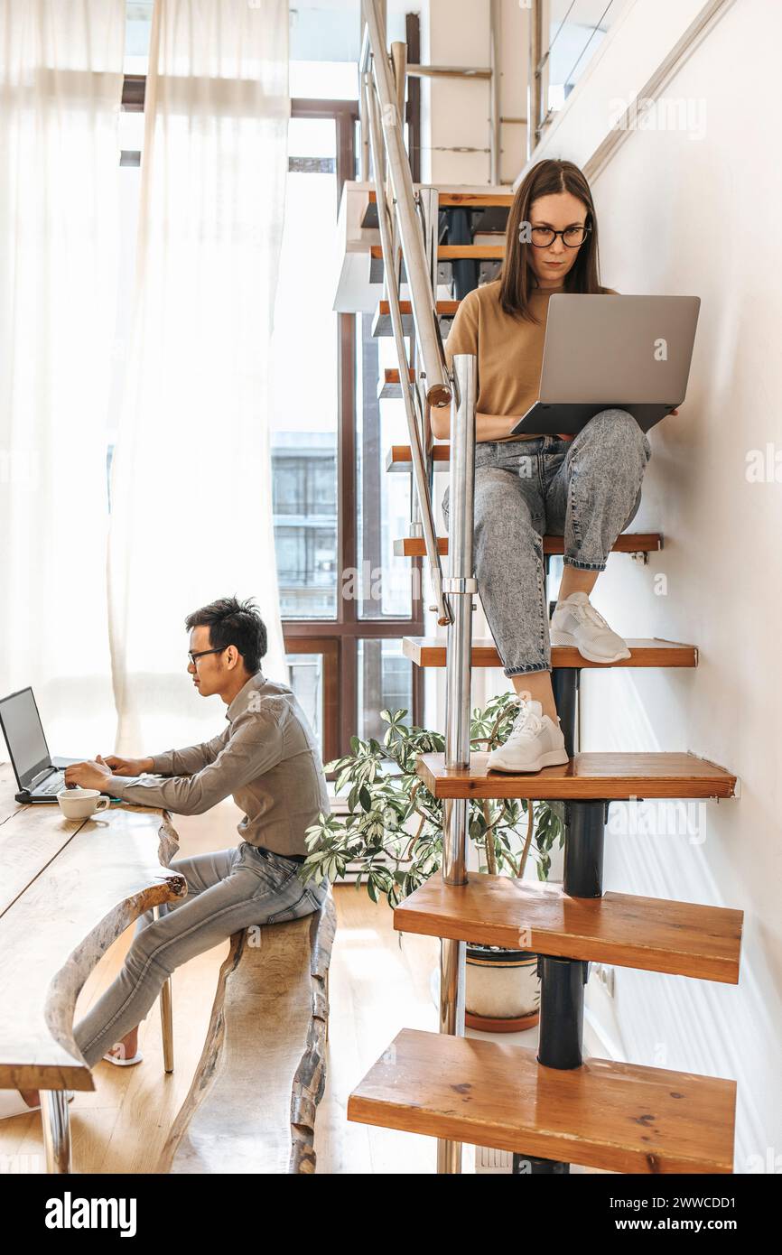 IT technicians coding through laptops at creative startup office Stock Photo - Alamy