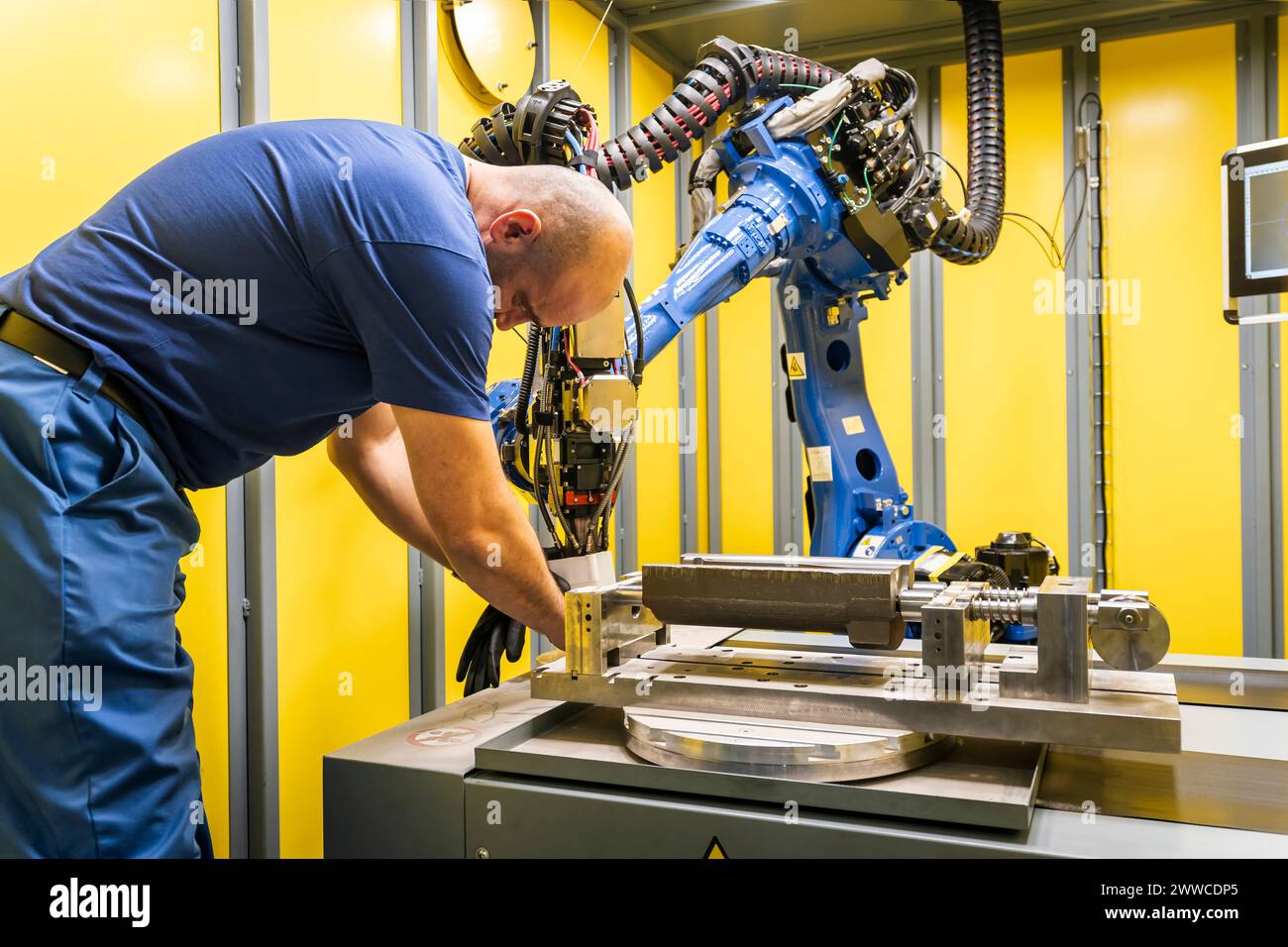 Maintenance engineer working with blue robotic arm in modern factory Stock Photo - Alamy