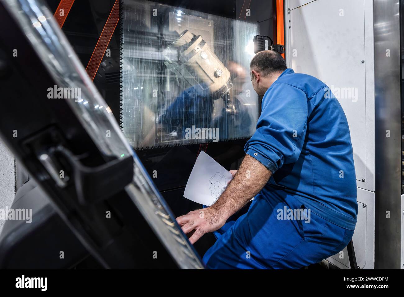 Technician operating machinery in modern factory Stock Photo - Alamy