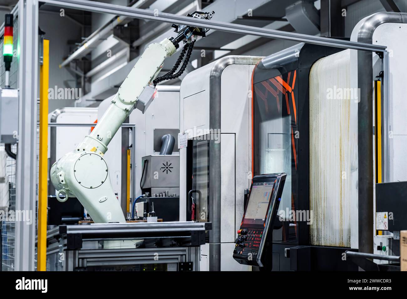 White robotic arm by CNC machinery in modern factory Stock Photo - Alamy
