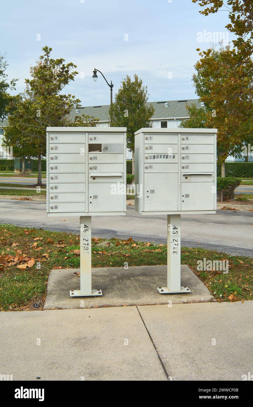 Image of two white community mailboxes lined up on the edge of a street ...