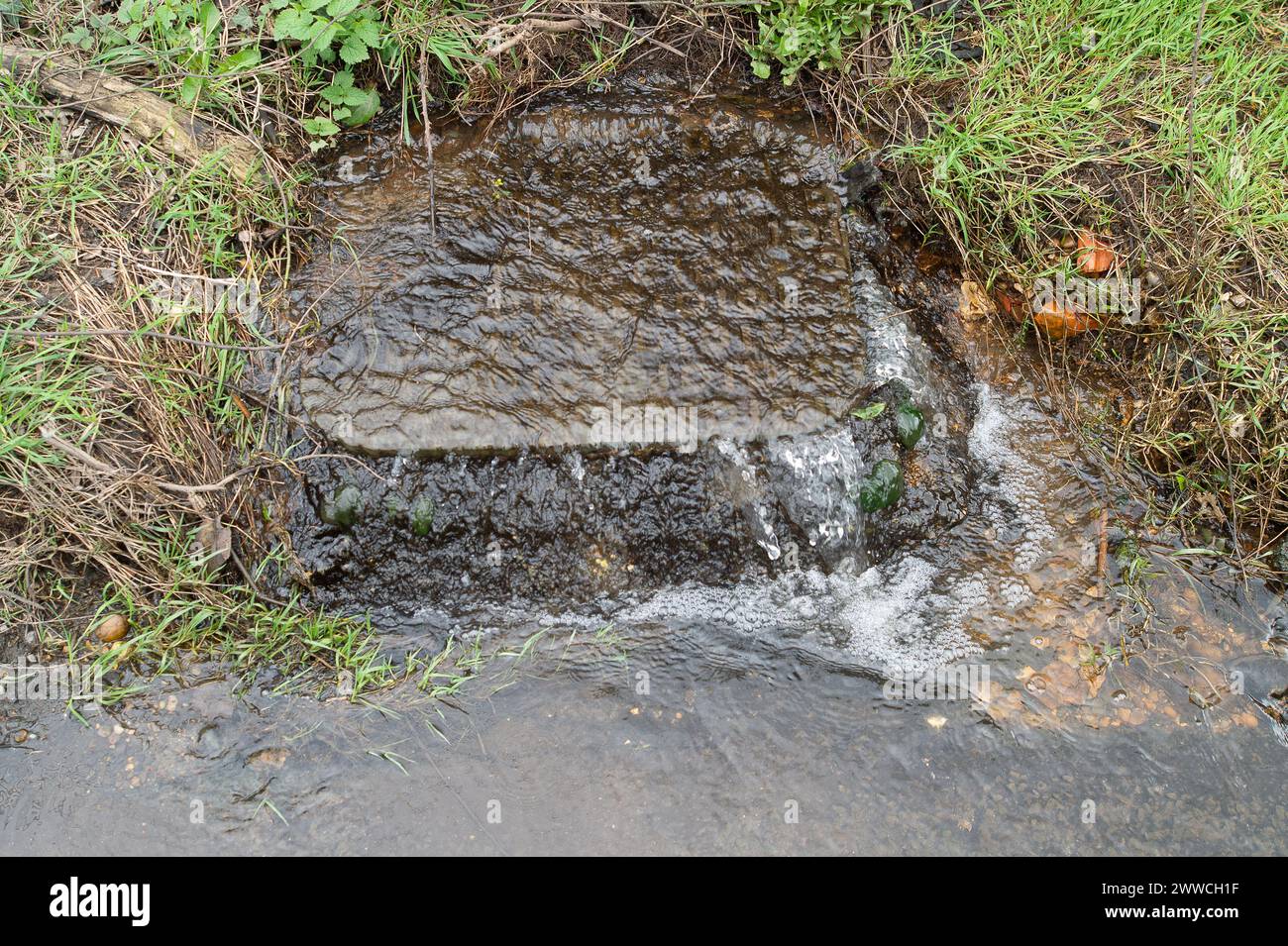 Slough, UK. 21st March, 2024. Water has been flowing out of a manhole ...