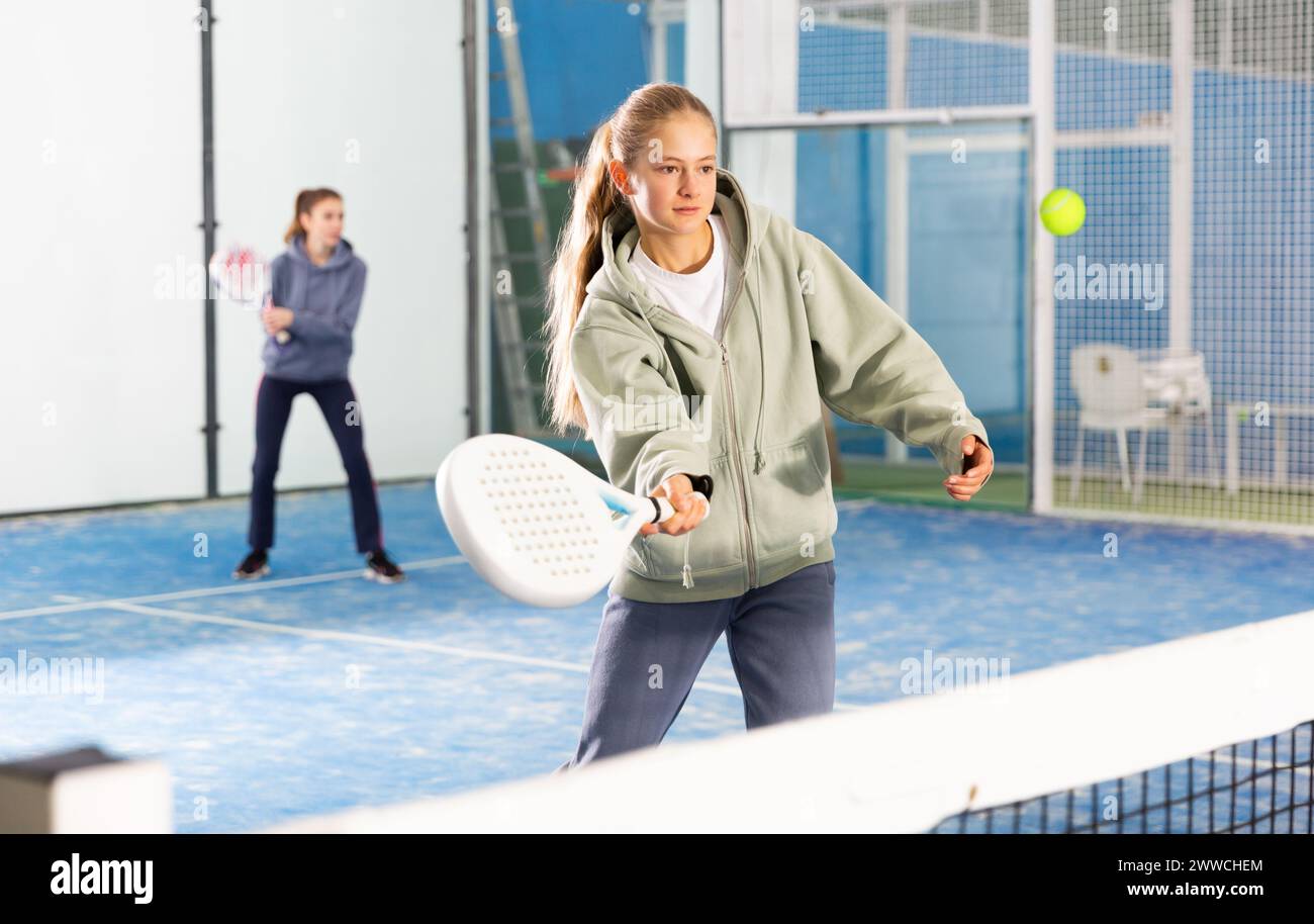 Teenage girl playing padel in court Stock Photo - Alamy