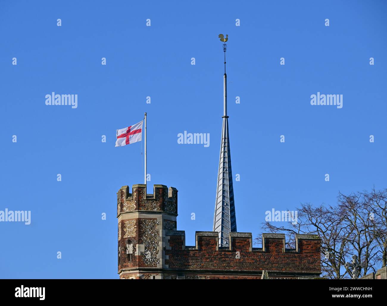 St George's flag and weather vane on tower of St Mary's church, Hitchin, Hertfordshire, England ...