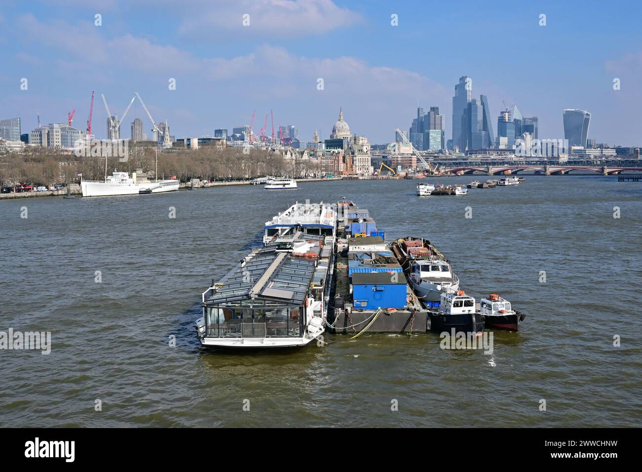 Barges and boats moored on the River Thames near Waterloo Bridge with ...