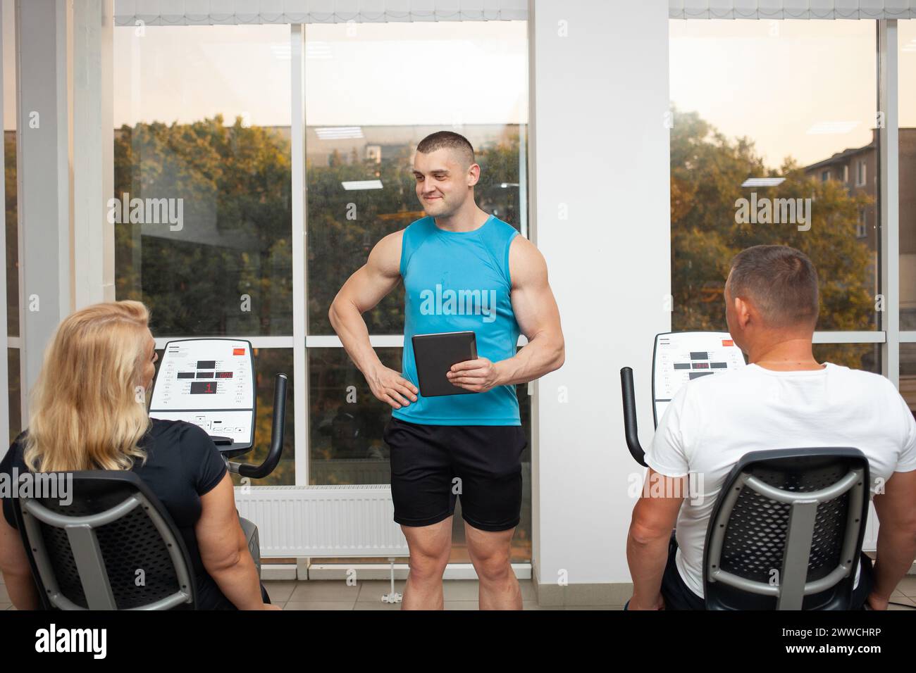 the trainer helps to perform the exercise on the simulator. Weight loss ...