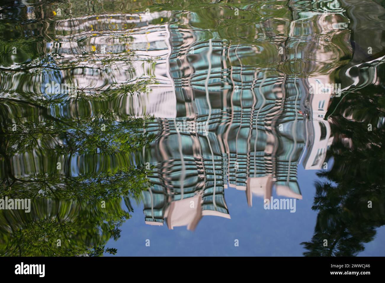 The wavy reflection of city apartment buildings mirrors the instability ...