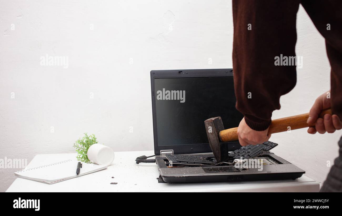 A man office worker smashed a laptop, destroyed a computer. Anger ...