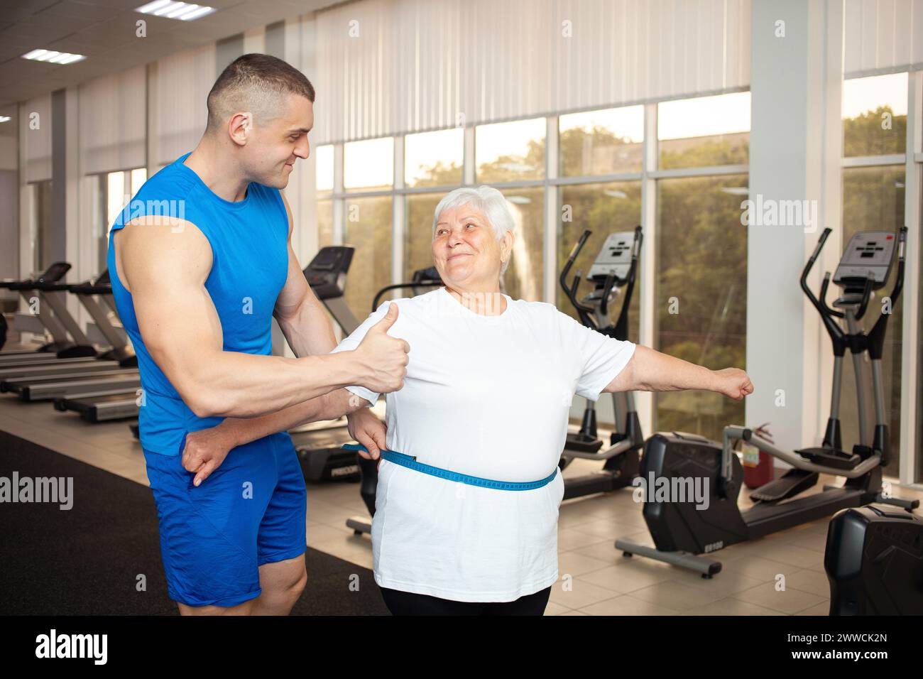 The trainer measures the volume, waist, centimeters of the body. An ...