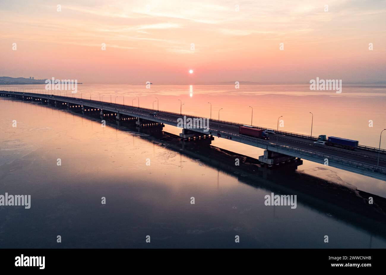 Aerial drone view of low-water bridge across the bay with moving car ...