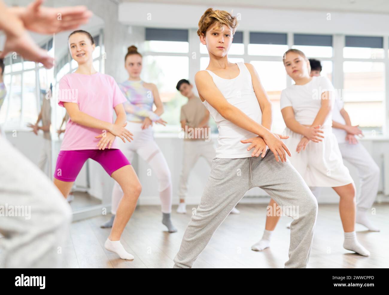 Team of teenagers rehearsing modern dances in dance hall Stock Photo ...
