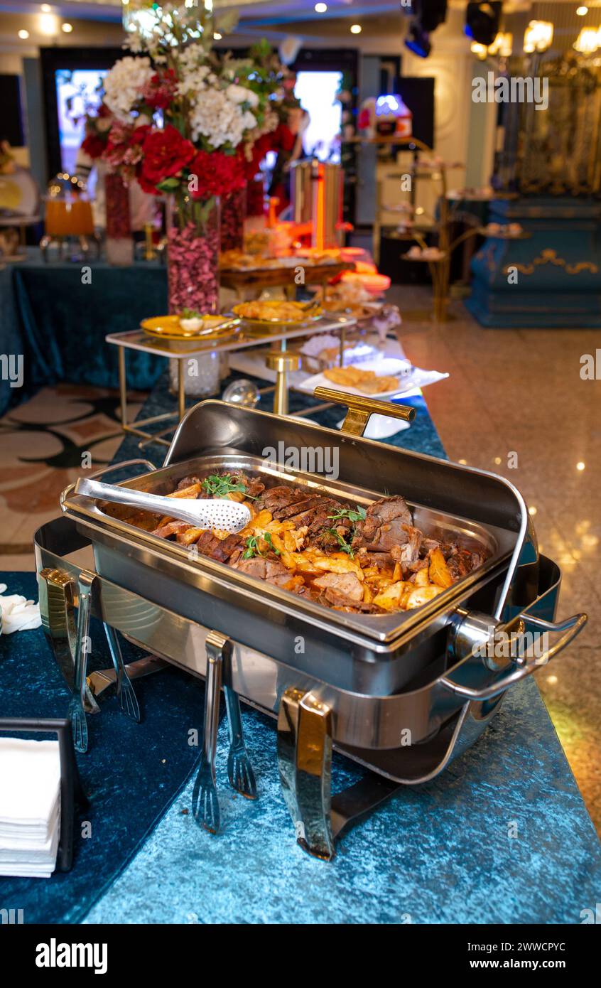 A buffet food warmer filled with delicious beef. The beef is cooked to ...