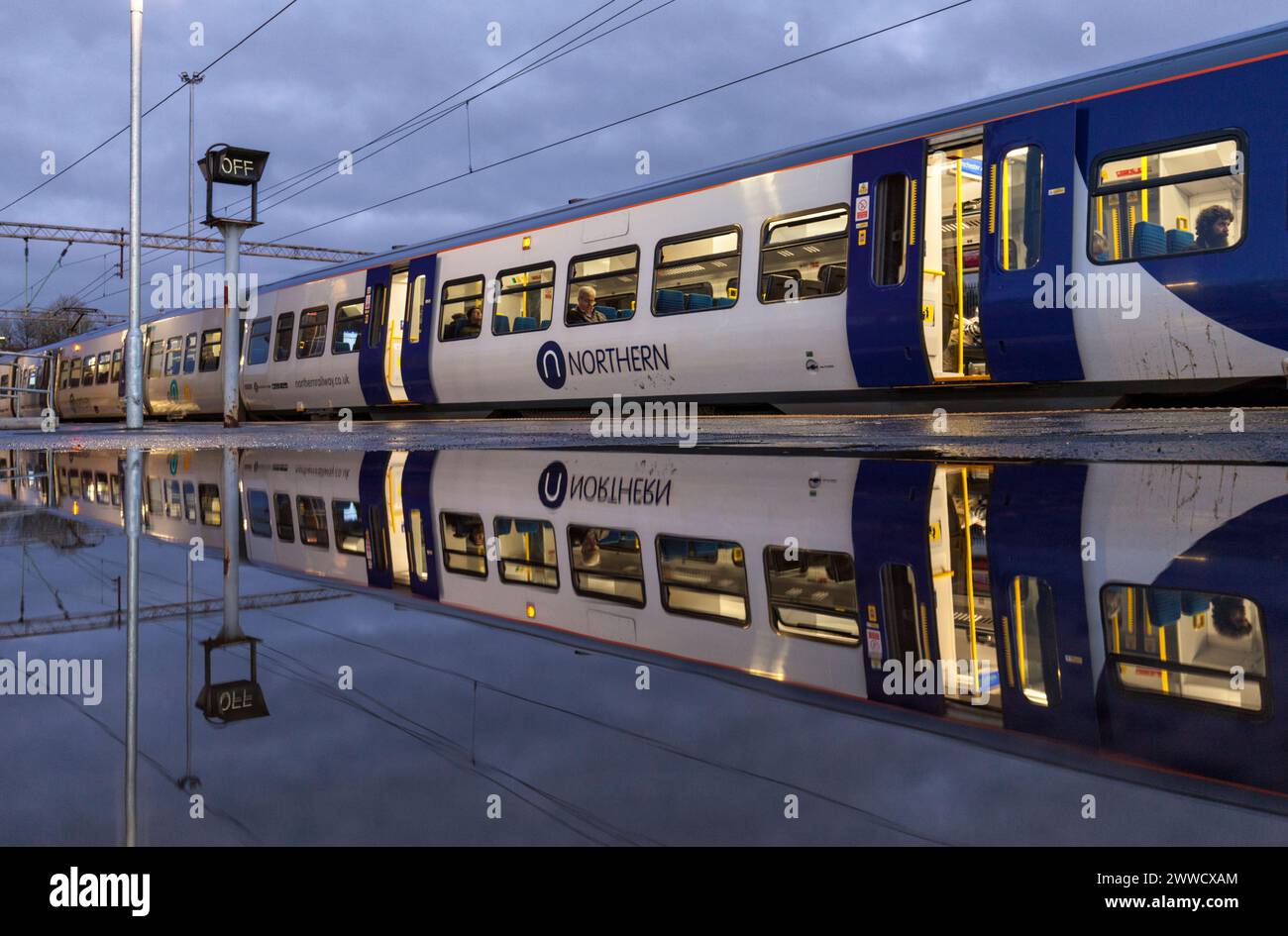 Northern Rail train at Edge Hill, Liverpool, UK reflected in a puddle ...
