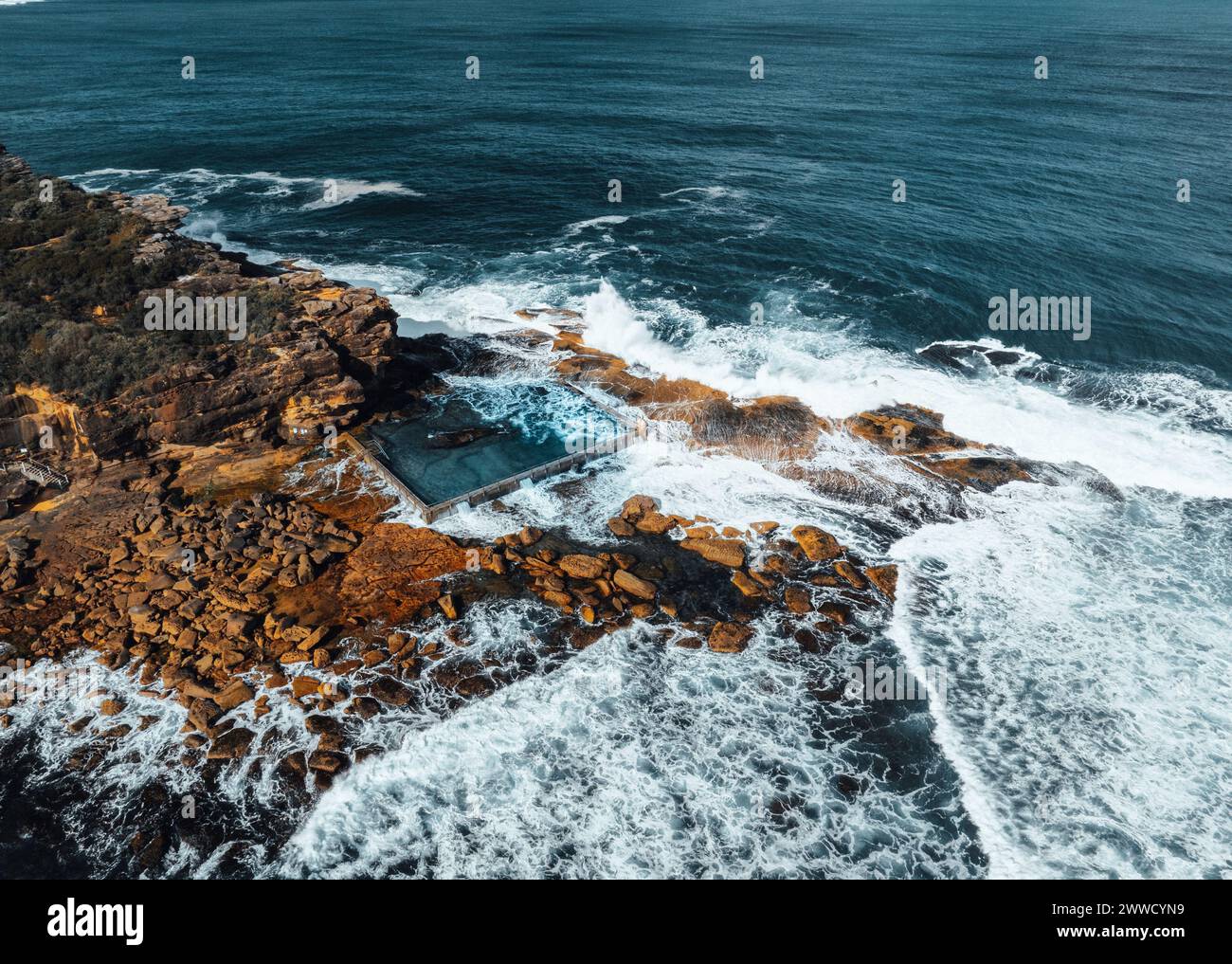 Aerial view early morning light with ocean waves flowing over rocks ...