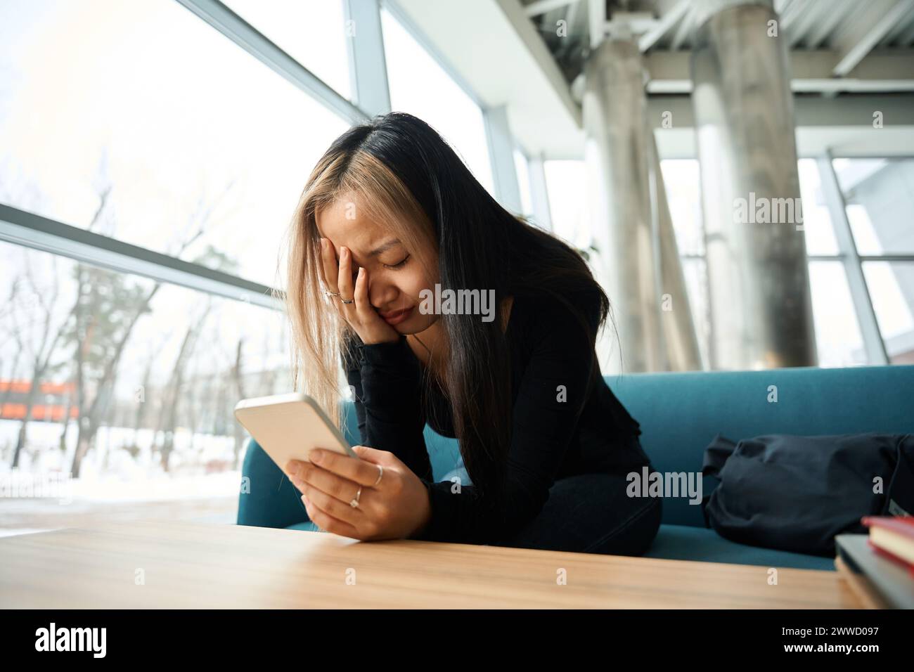 Young upset and crying asian female IT employee using smartphone Stock ...